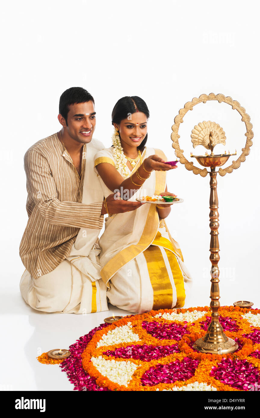 South Indian couple lighting oil lamp at Onam Stock Photo - Alamy