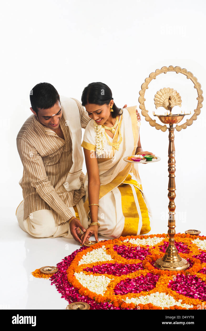 South Indian couple making a rangoli of flowers at Onam Stock Photo - Alamy