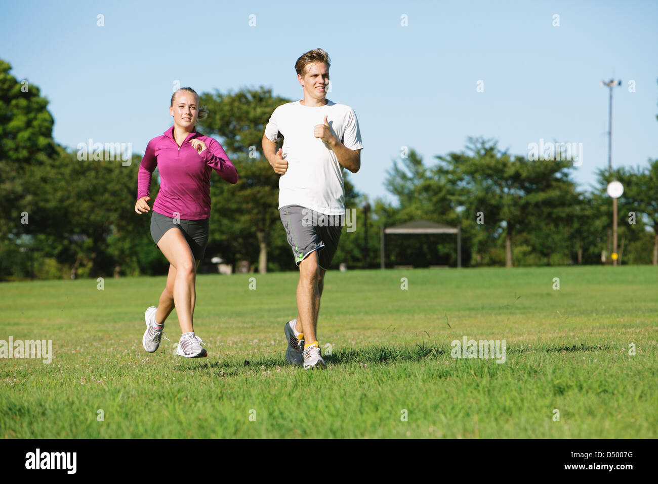 Couple running in a park Stock Photo - Alamy