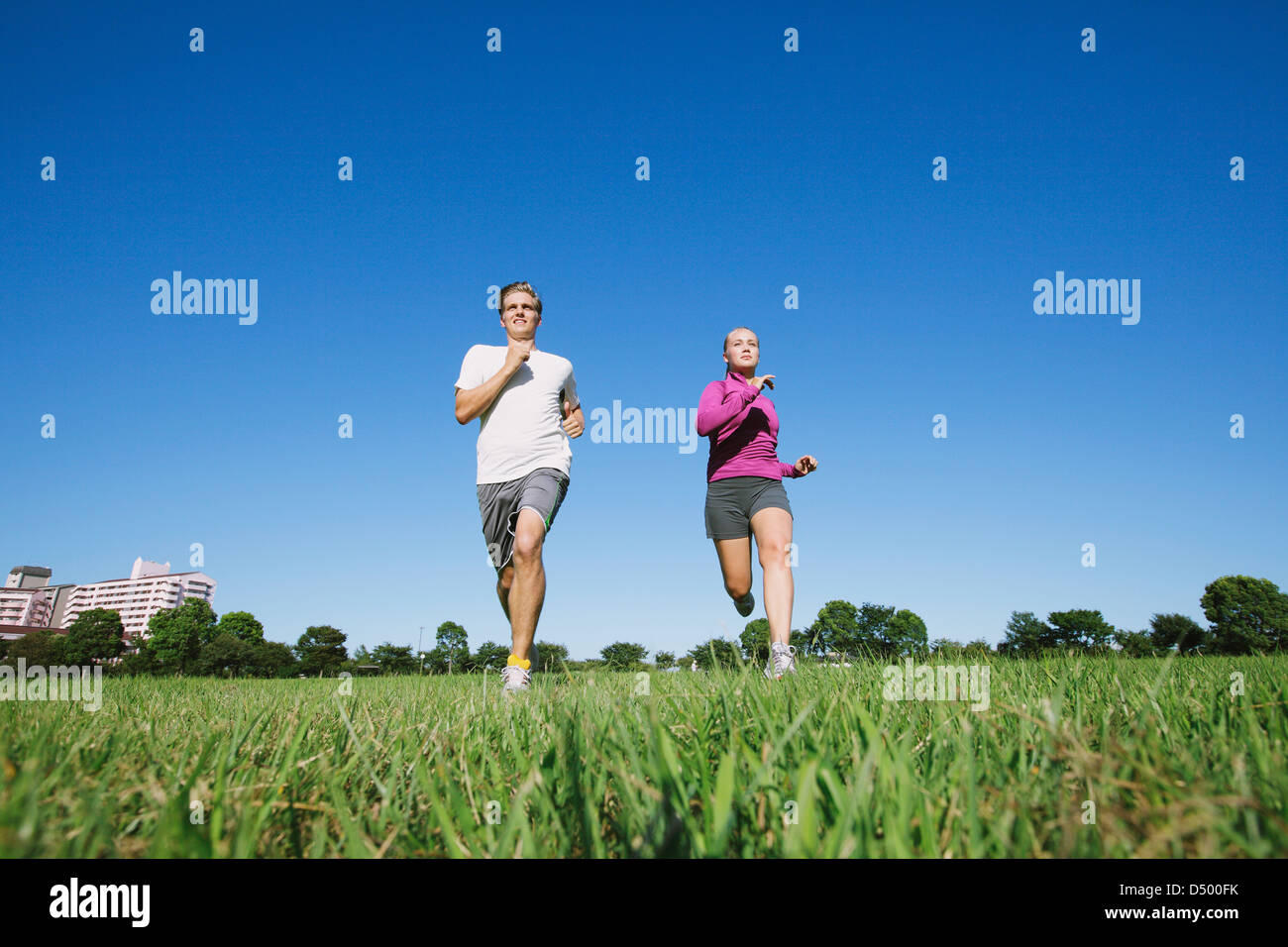 Couple running in a park Stock Photo - Alamy