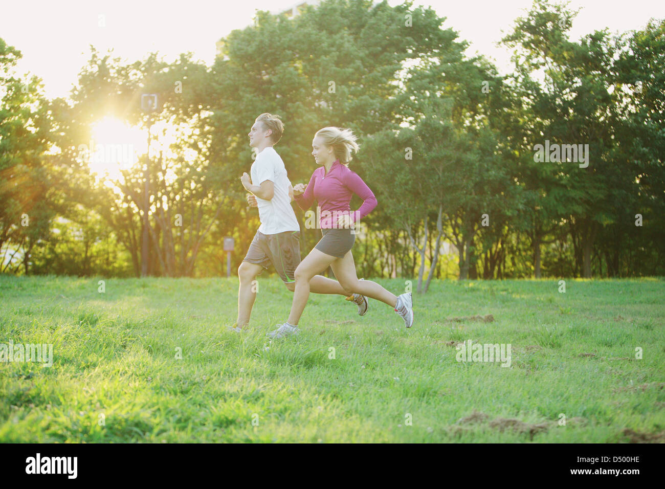 Couple running in a park Stock Photo - Alamy