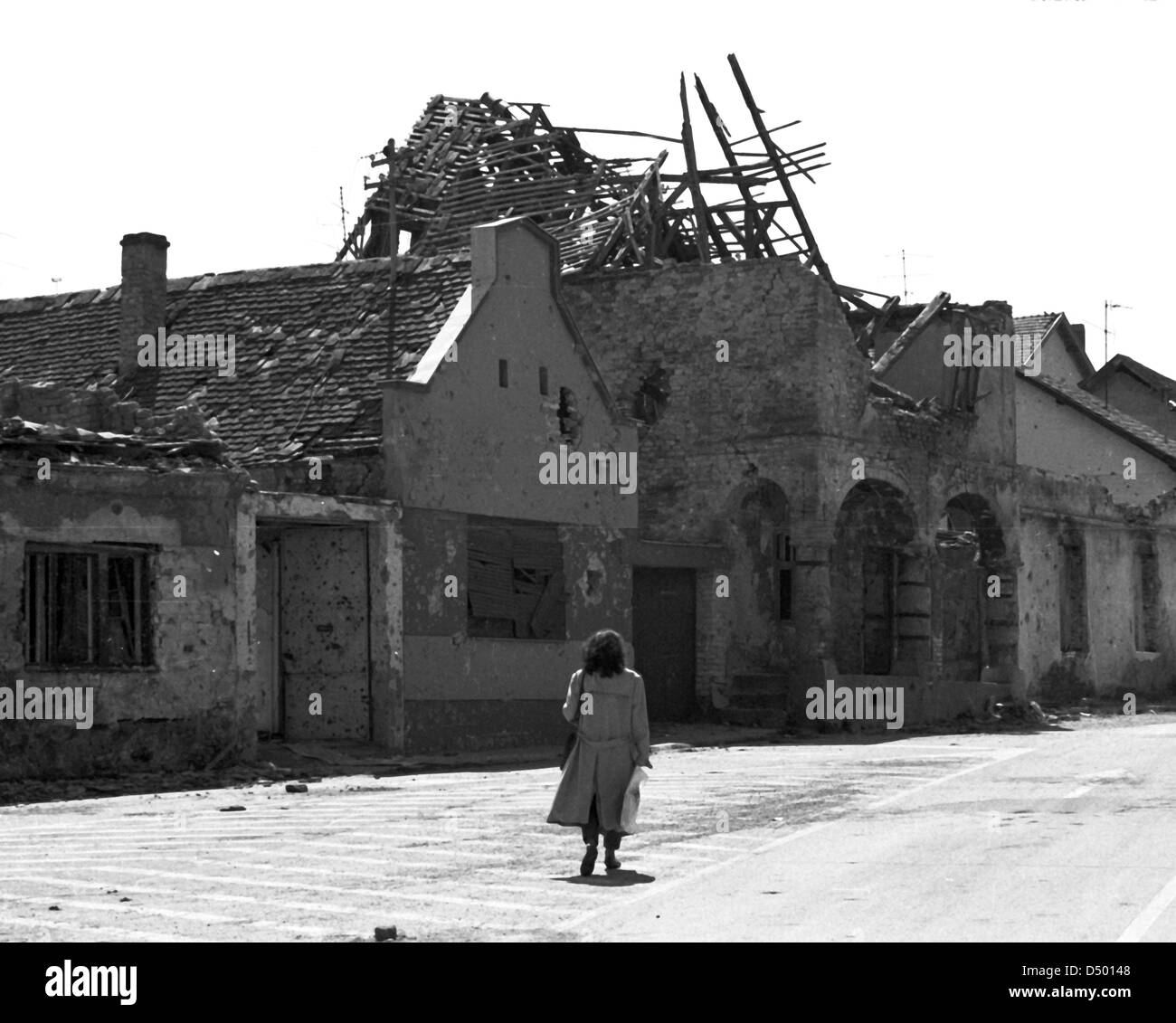A woman walks through the destroyed center city of Vukovar, Croatia, on ...