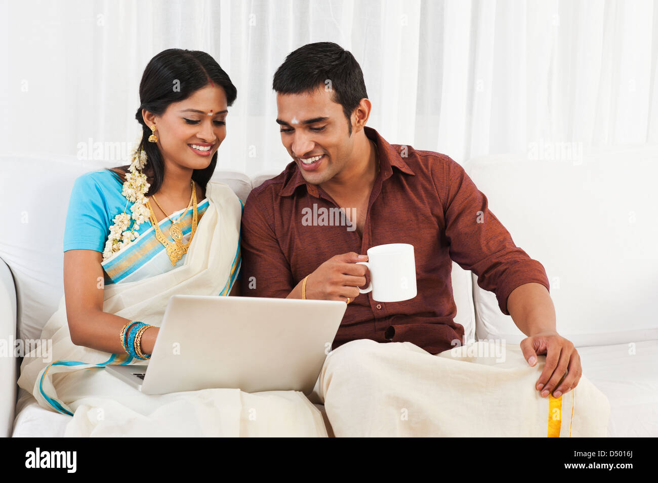 South Indian couple using a laptop Stock Photo - Alamy