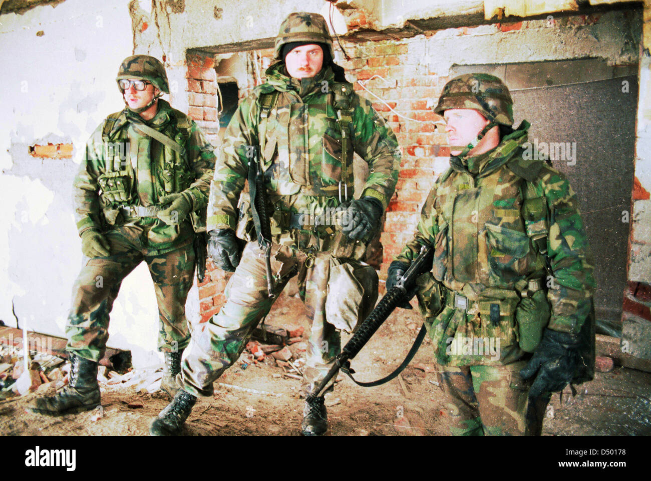 United States Army troops, in Bosnia as part of NATO's IFOR, protect a ...