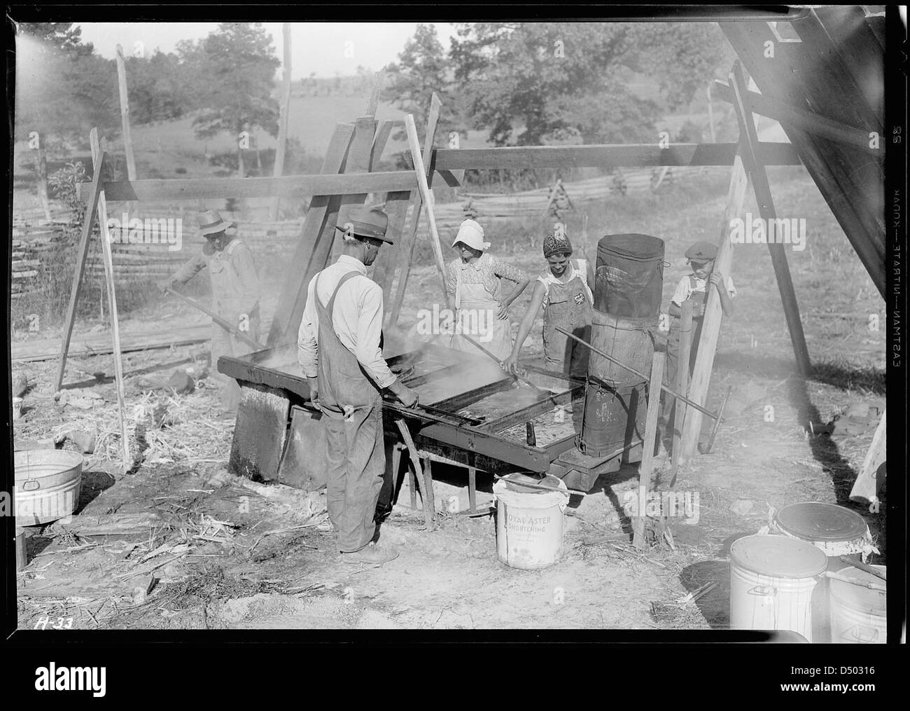 A 1933 image from Lewis Hine shows the process of making sorghum ...