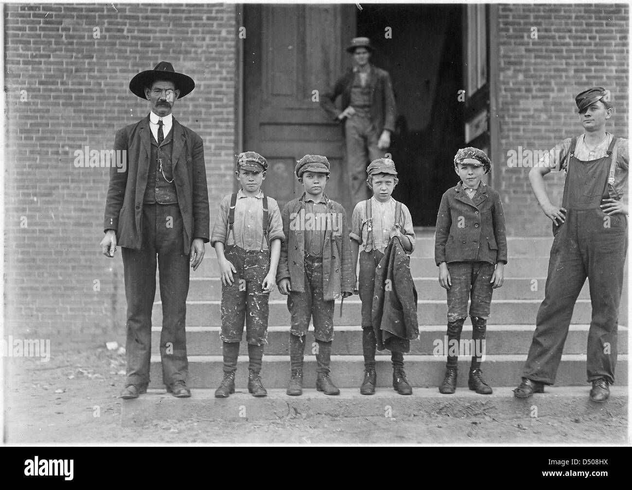 A photograph from November 1908 shows an 11-year-old boy holding a coat ...