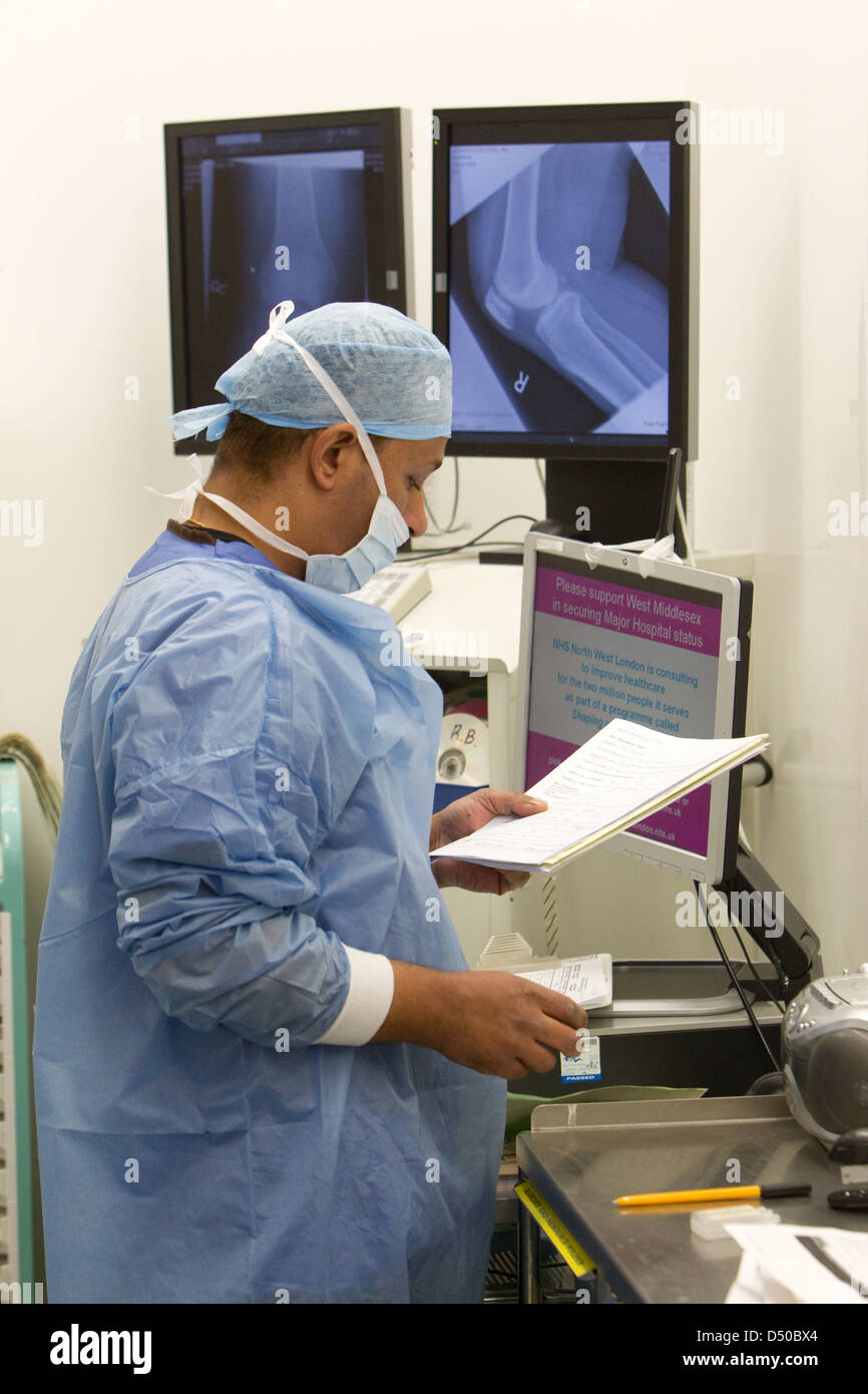 Anaesthestist checking notes during an operation Stock Photo - Alamy