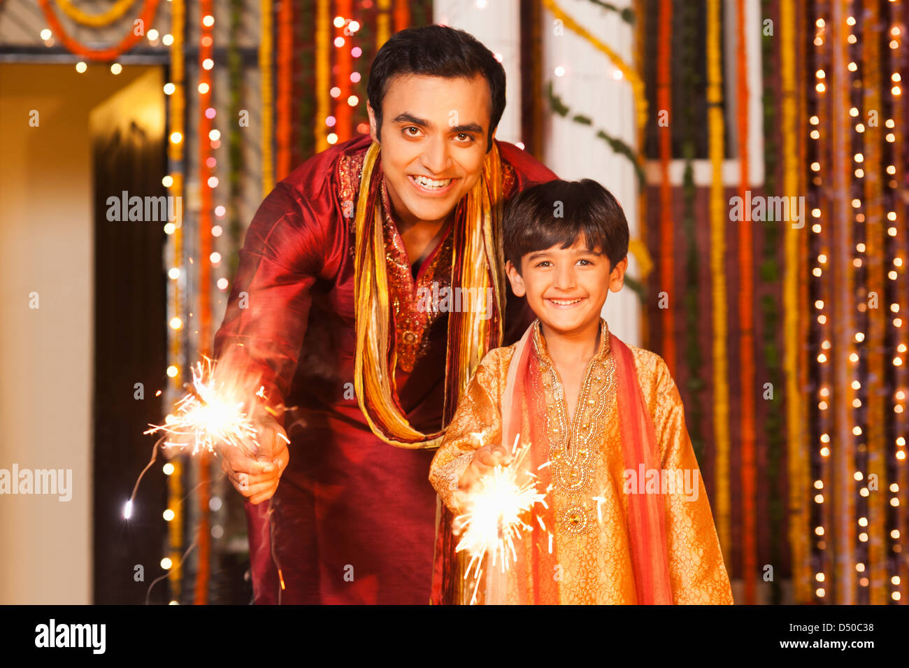 Man and his son burning fire crackers on Diwali Stock Photo - Alamy
