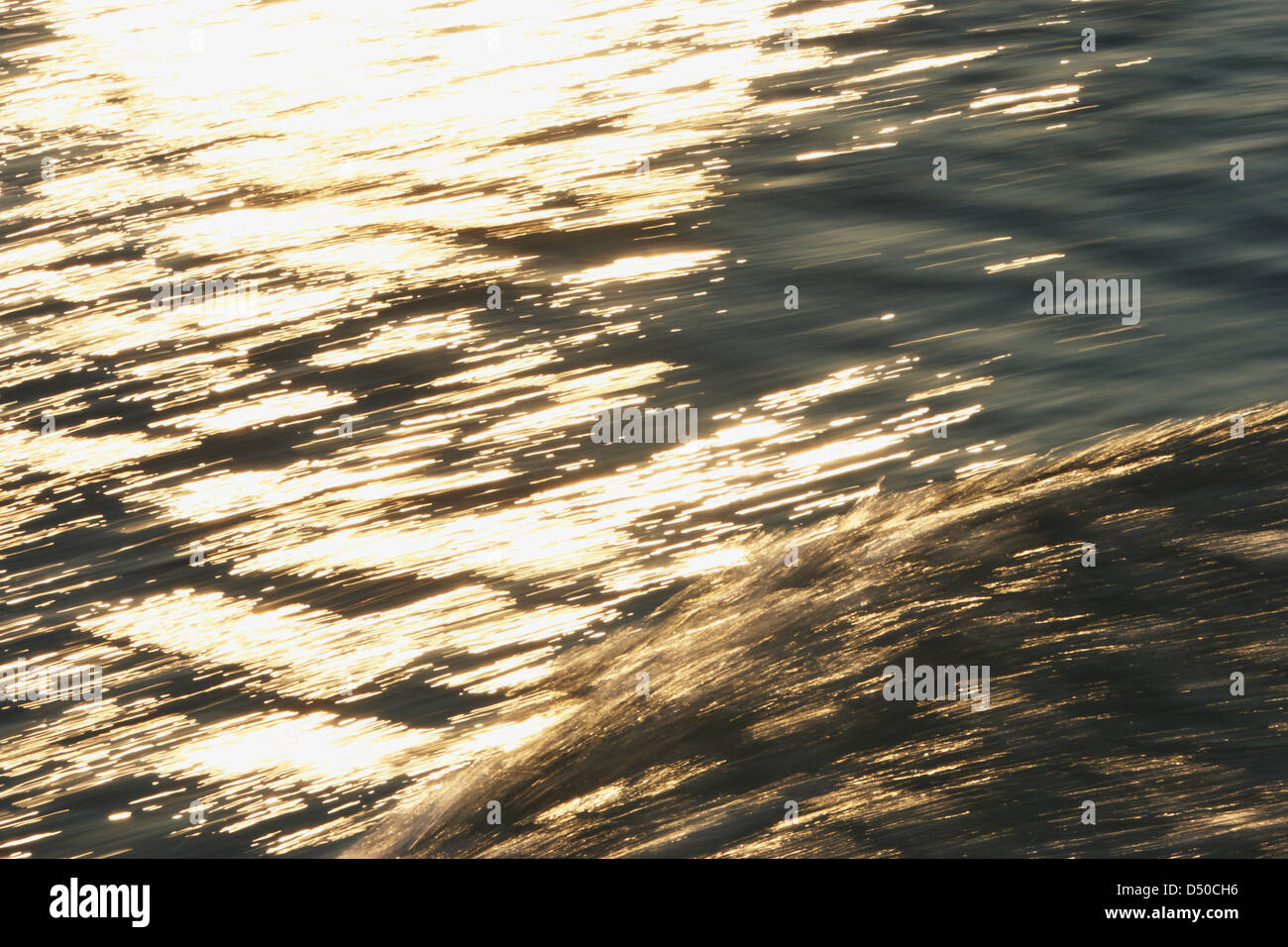 Water waves at sunset Stock Photo - Alamy