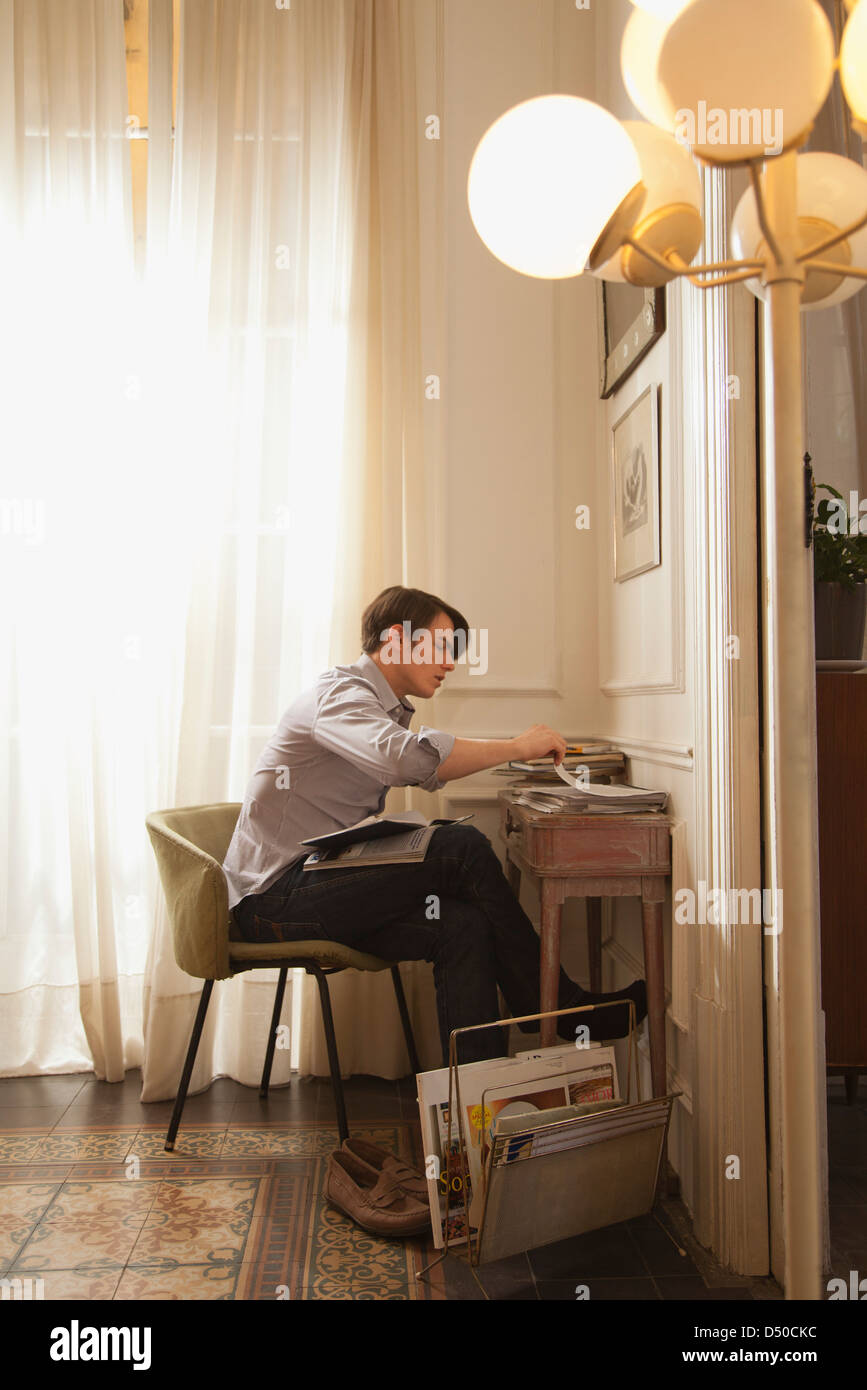 Man reading at desk at home Stock Photo - Alamy
