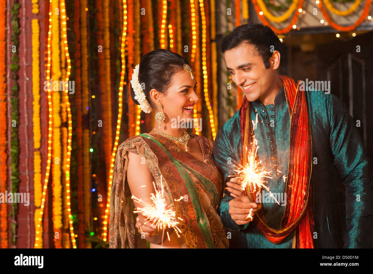 Couple burning fire crackers on Diwali Stock Photo - Alamy