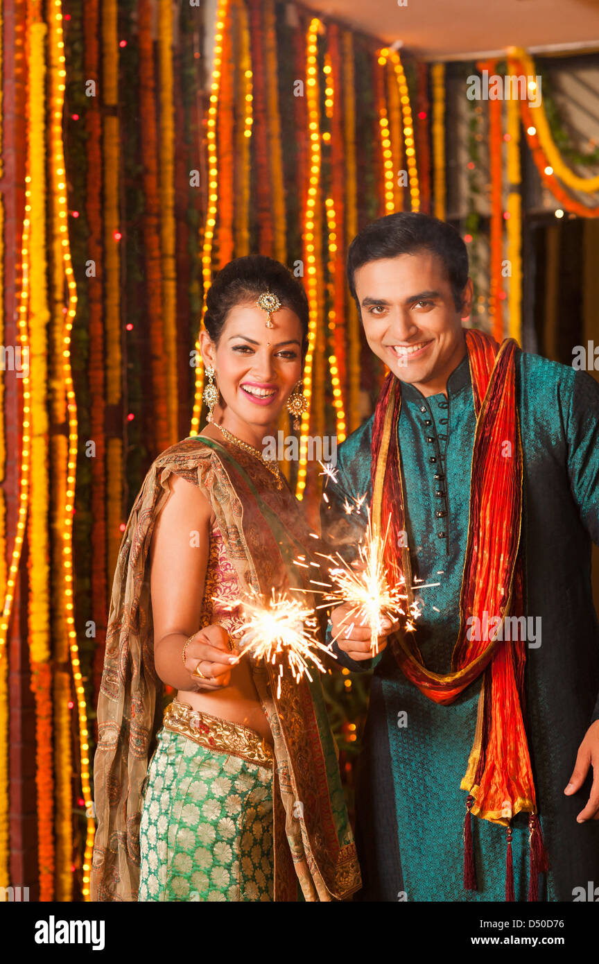 Couple burning fire crackers on Diwali Stock Photo - Alamy