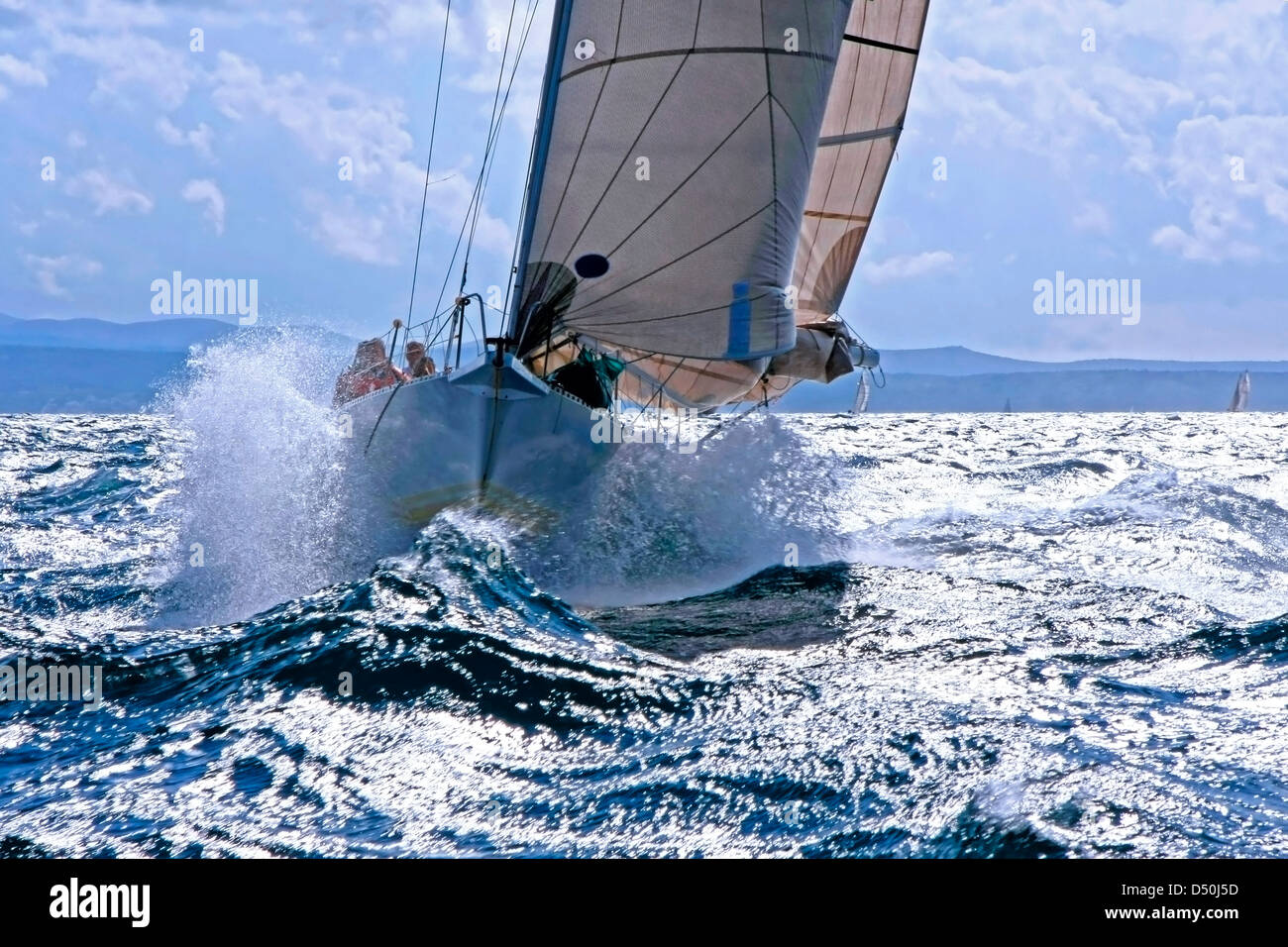 Sailboat breaking through the splashing wave Stock Photo - Alamy