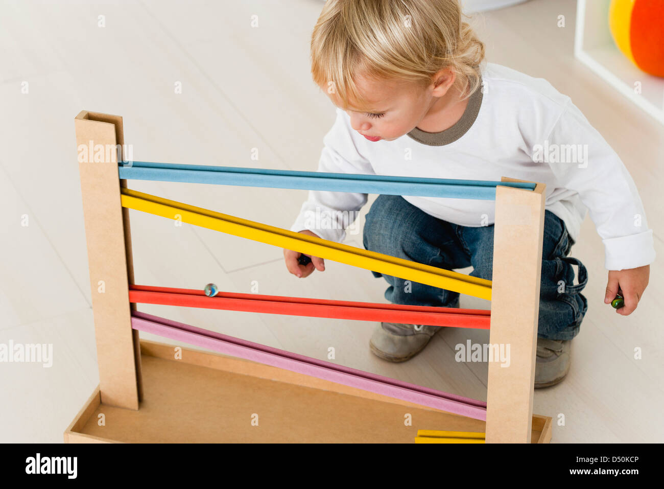 Baby watching marble rolling down bars Stock Photo - Alamy