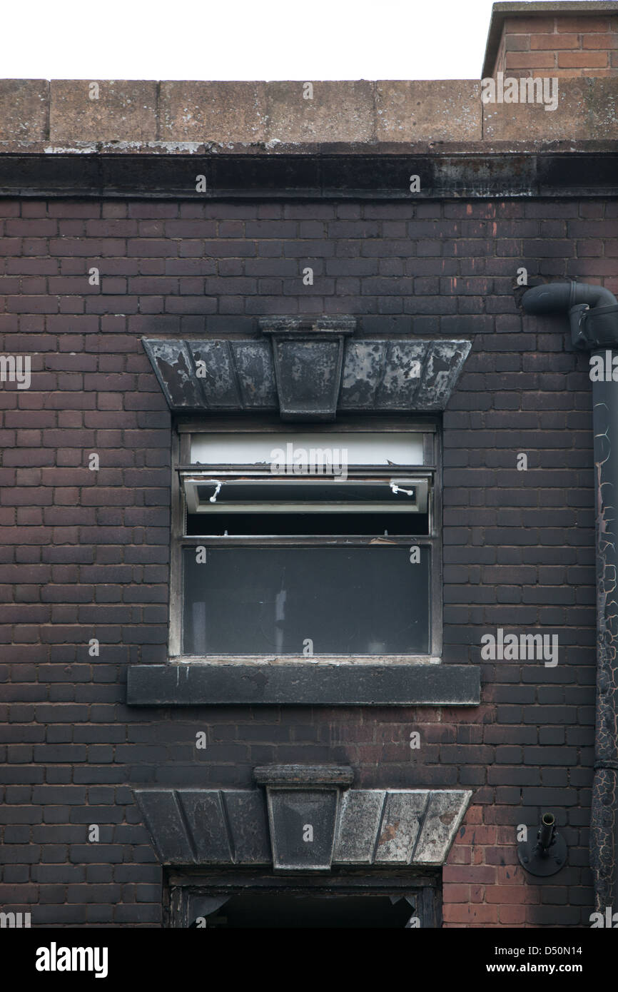 A fire blackened building after a severe fire. detail of a top floor ...