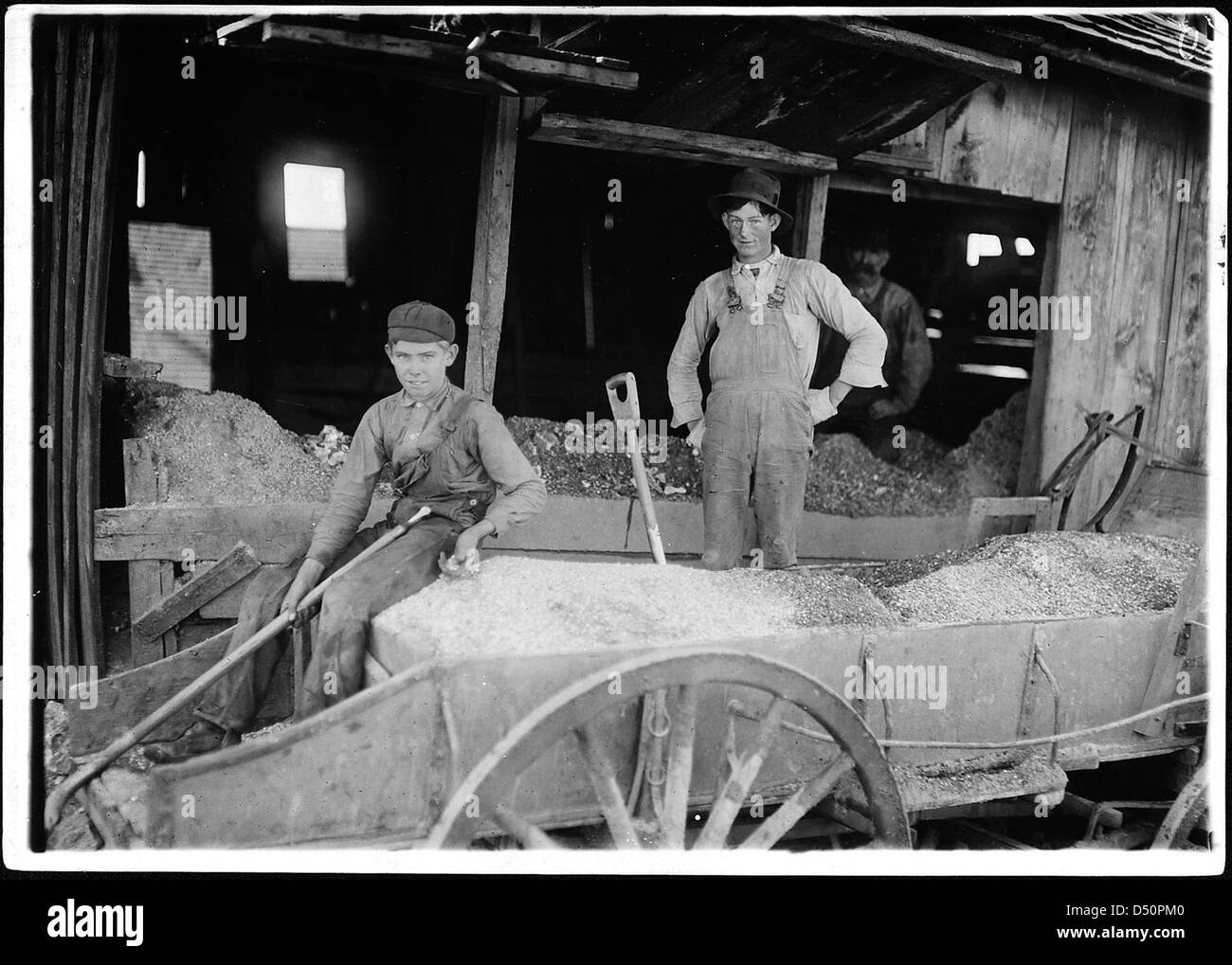 A 1912 photograph by Lewis Hine showing a young boy and two men ...