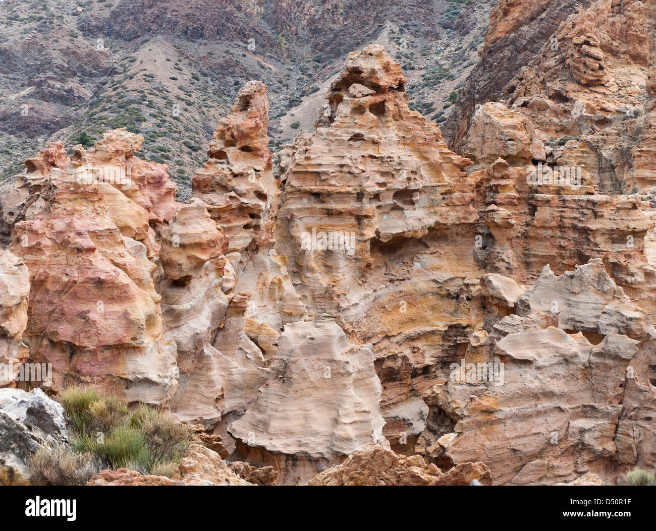 Volcanic rock formations in shades of yellow pink orange and brown, in ...