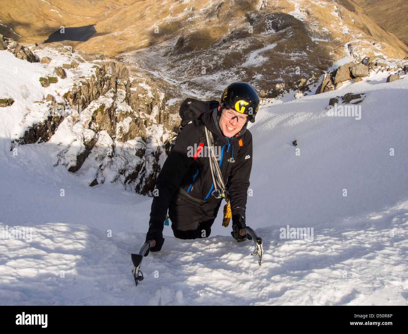 A winter climber descending Custs Gully on Great End, Lake District, UK ...