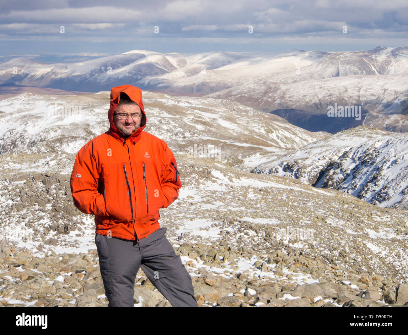 A walker on the summit of Scafell Pike, Lake district, UK, the highest ...