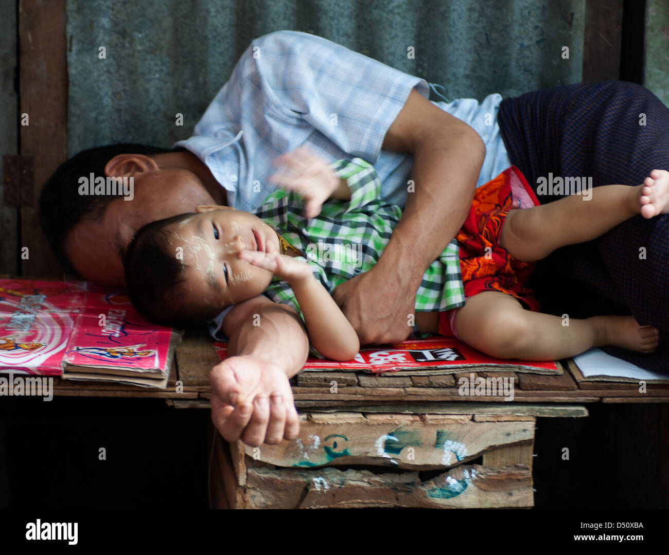 A father in Yangon Myanmar takes a nap with his still very much wide ...
