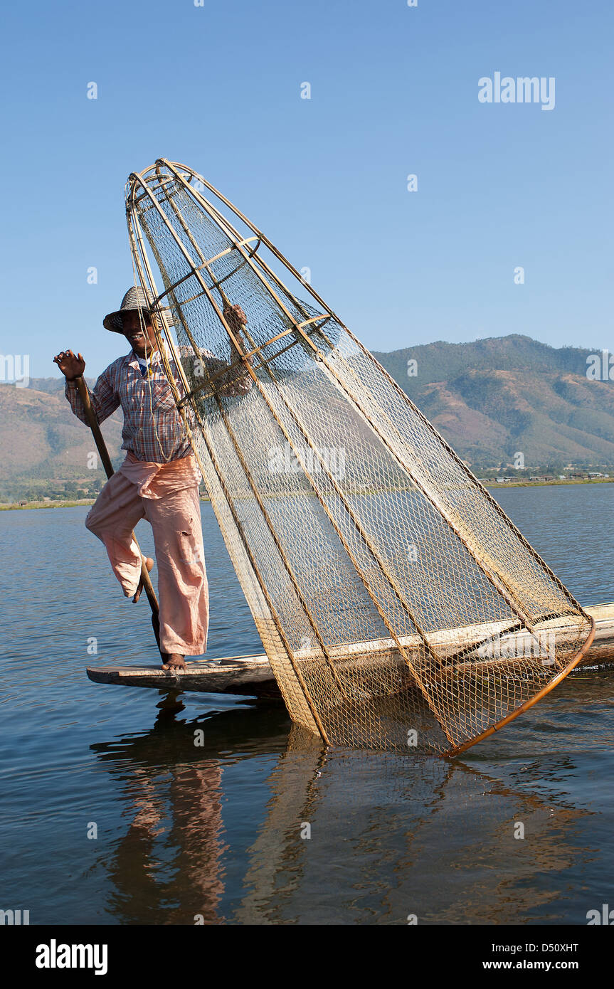 The Intha fishermen of Inle Lake, Myanmar stand on one leg, paddle with ...