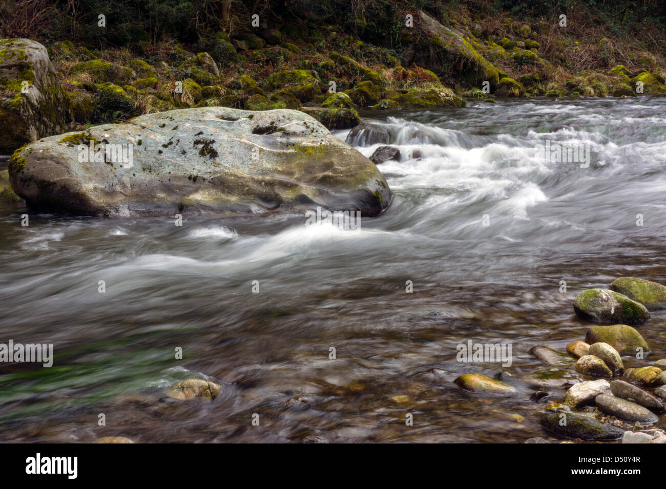 Flowing river with rounded stones on the beach Stock Photo - Alamy