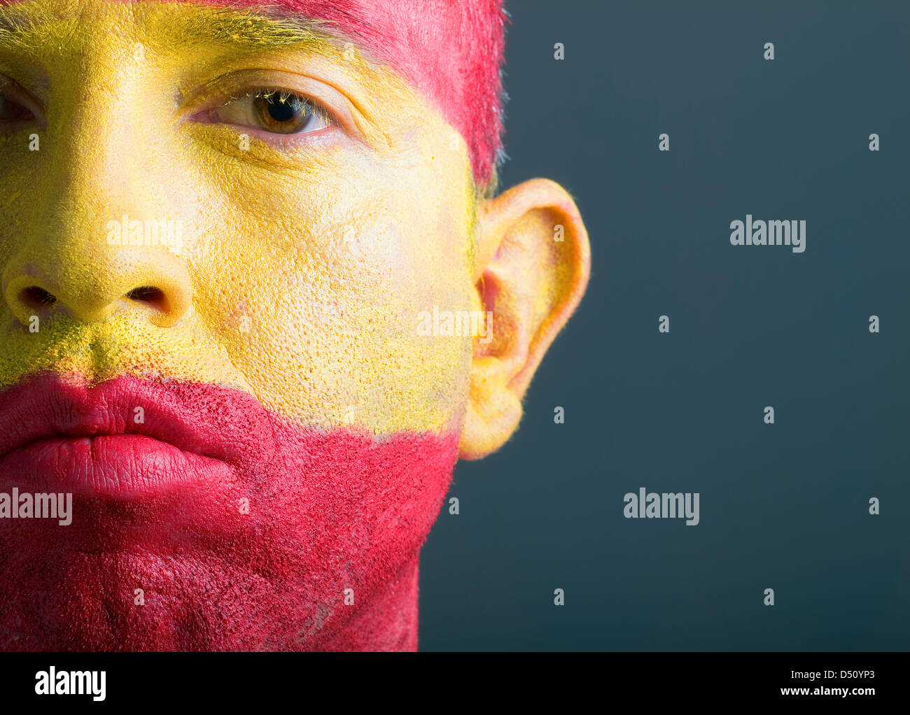 Man with his face painted with the flag of Spain. The man is serious ...