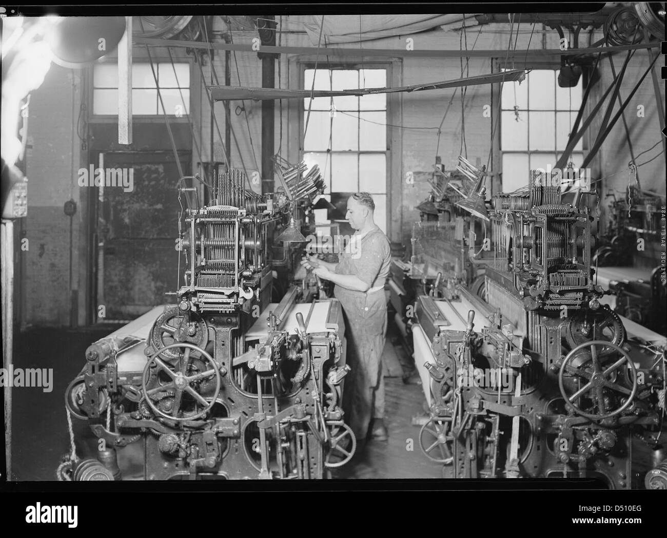 This 1936 photograph by Lewis Hine shows a weaver working a four-loom ...