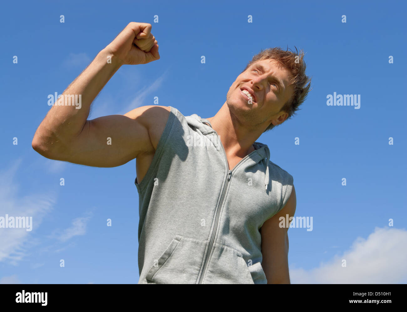 The winner. Energetic young man with his arm raised in joy Stock Photo ...