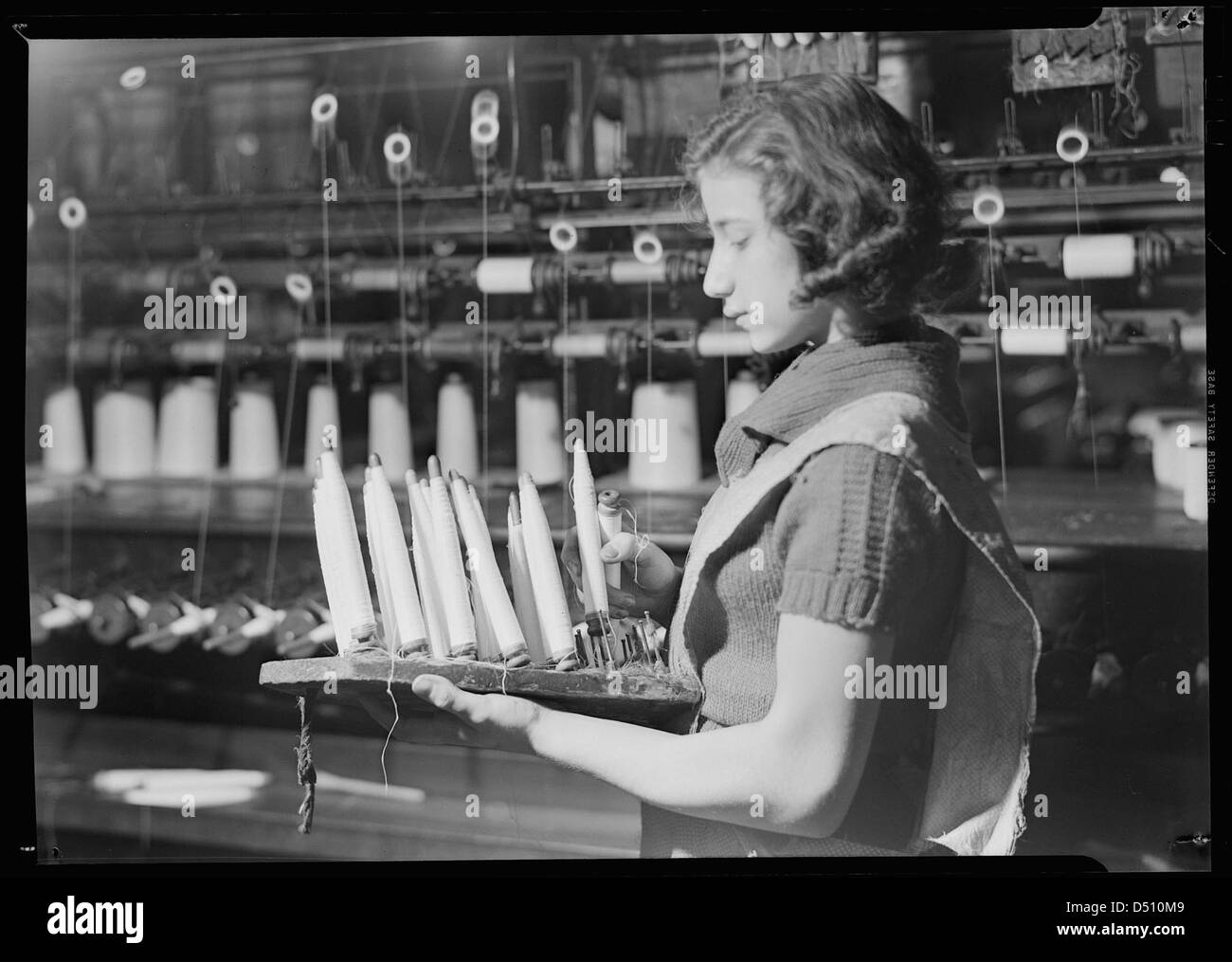 This 1937 photograph by Lewis Hine shows a quiller with a rack of ...