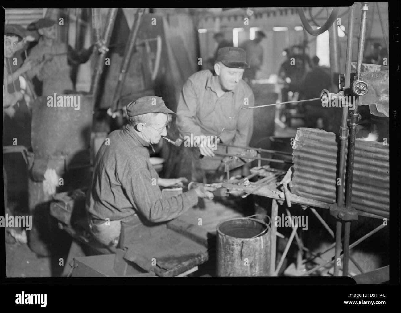A 1937 photograph shows a gaffer finishing a wide-mouthed glass bottle ...