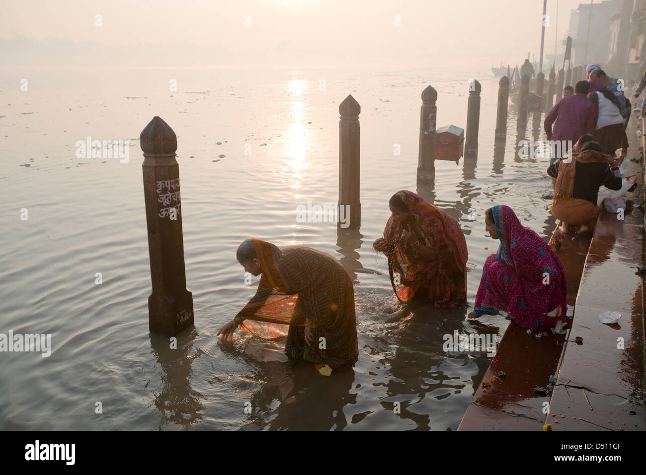 Hindu devotees practice ritual bathing as the sun rises over the Yamuna ...