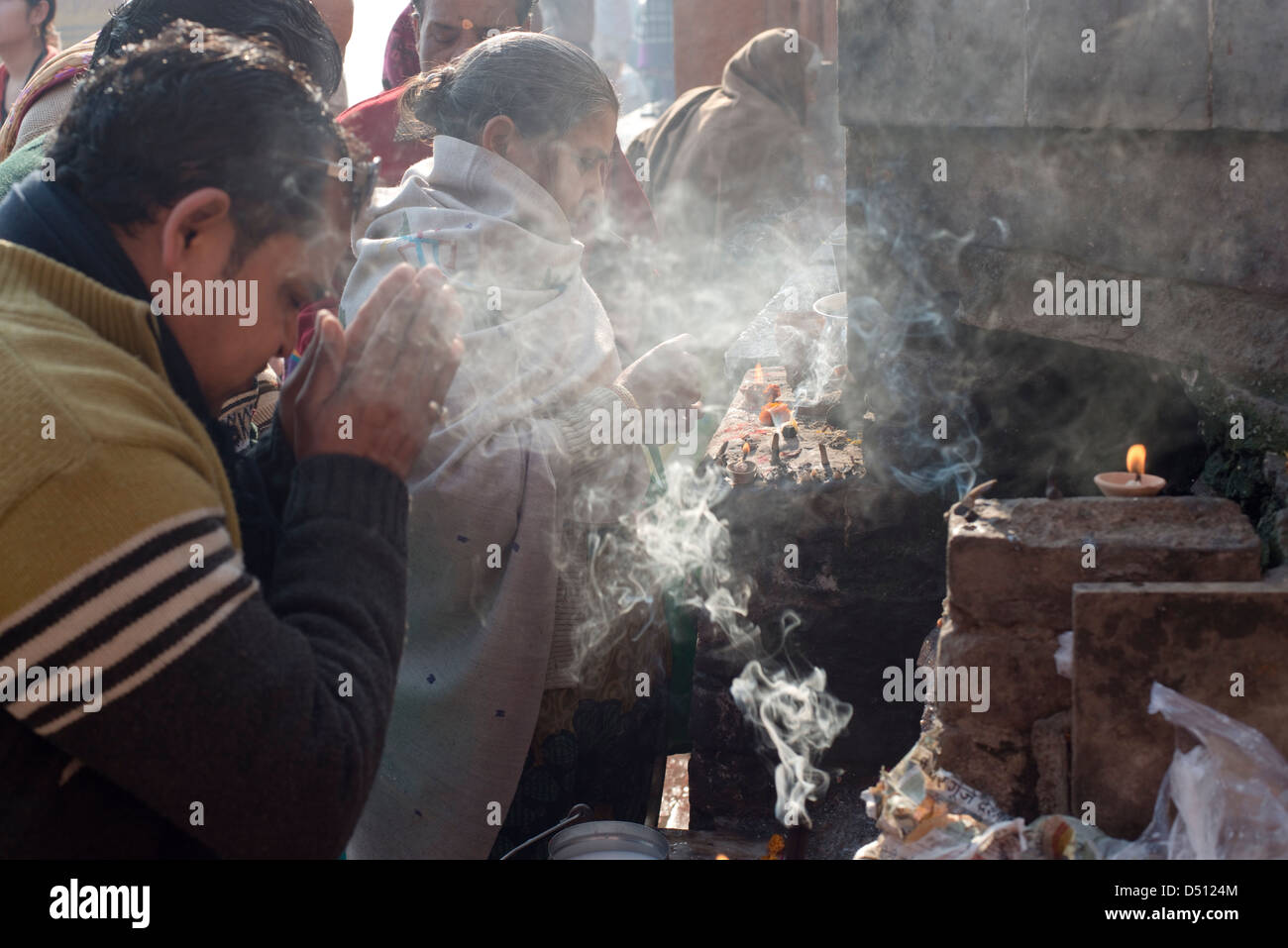 Smoke from incense and dhoop fills the air as Hindu devotees pray at a ...