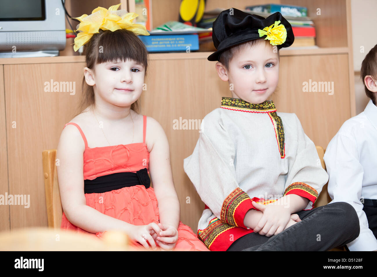 Cute boys and girls in Russian kindergarten sitting on the chairs in ...