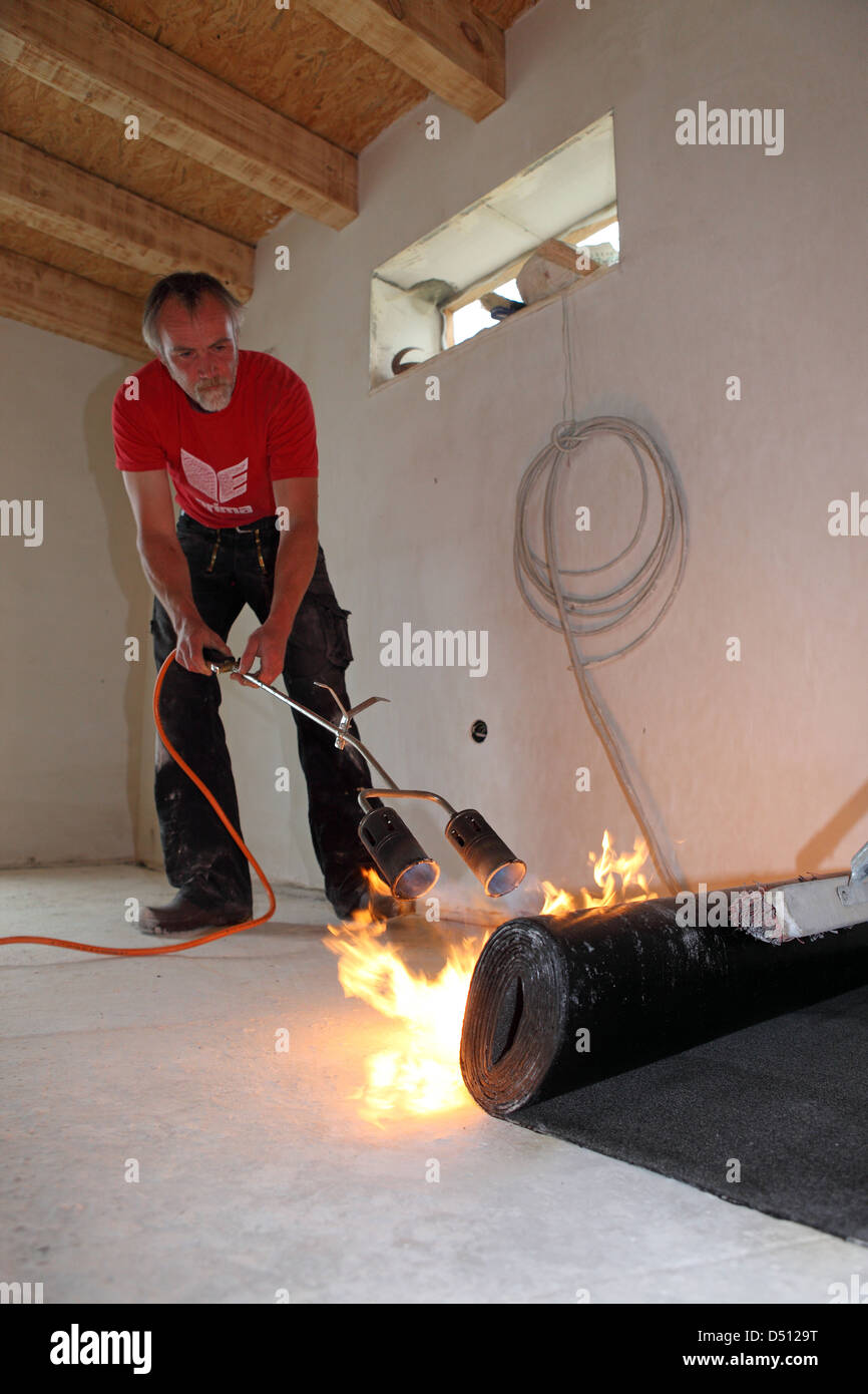 New Kätwin, Germany, man warmed up tar paper with a gas heating torch ...