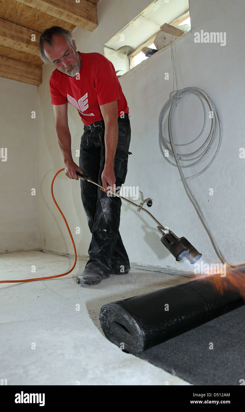 New Kätwin, Germany, man warmed up tar paper with a gas heating torch ...