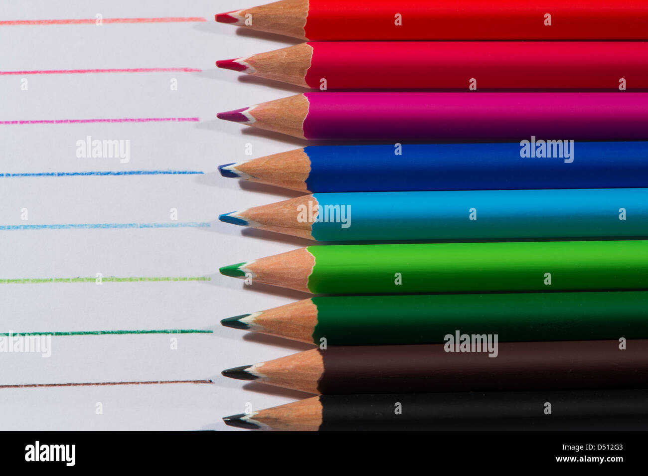Close-up detail of sharp colourful pencil crayons laid side by side on ...