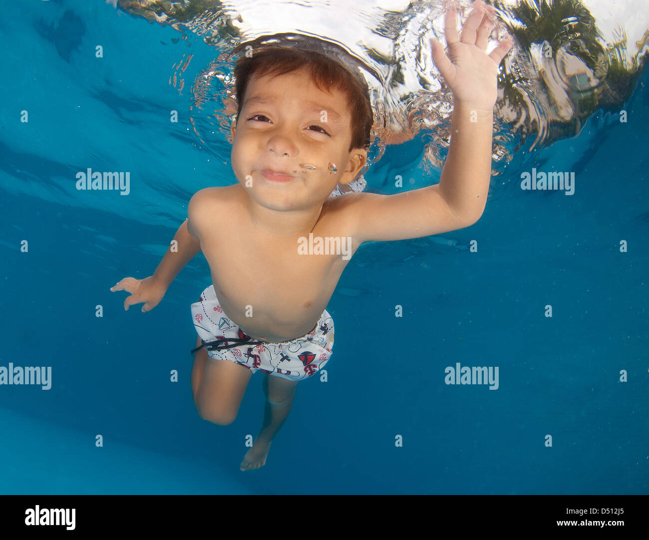 little 3 years old boy playing on the surface of a swimming pool Stock ...