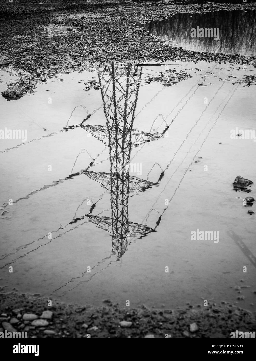 An electricity power pylon reflected in a puddle Stock Photo - Alamy