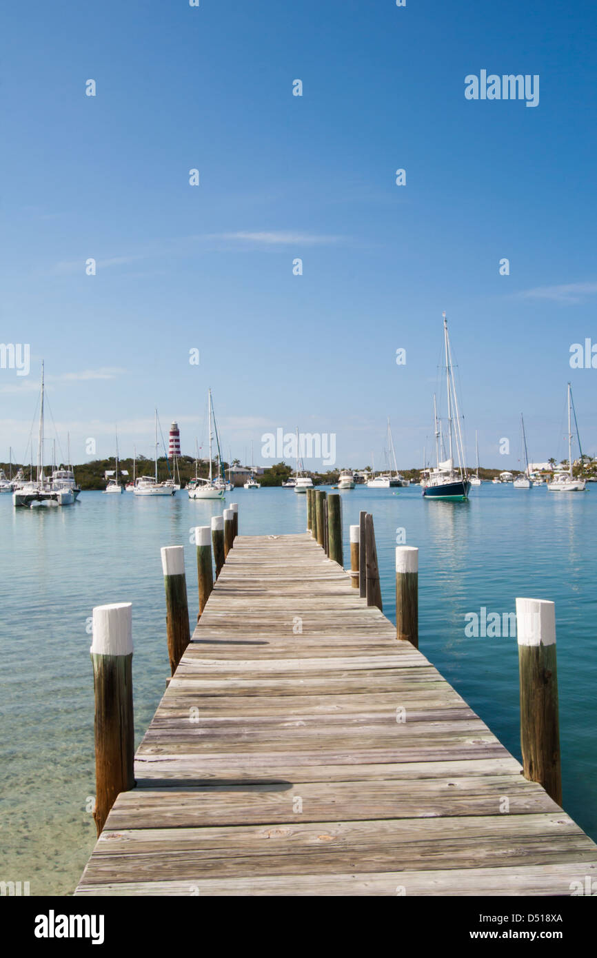 A jetty with Hope Town lighthouse in the background Stock Photo - Alamy