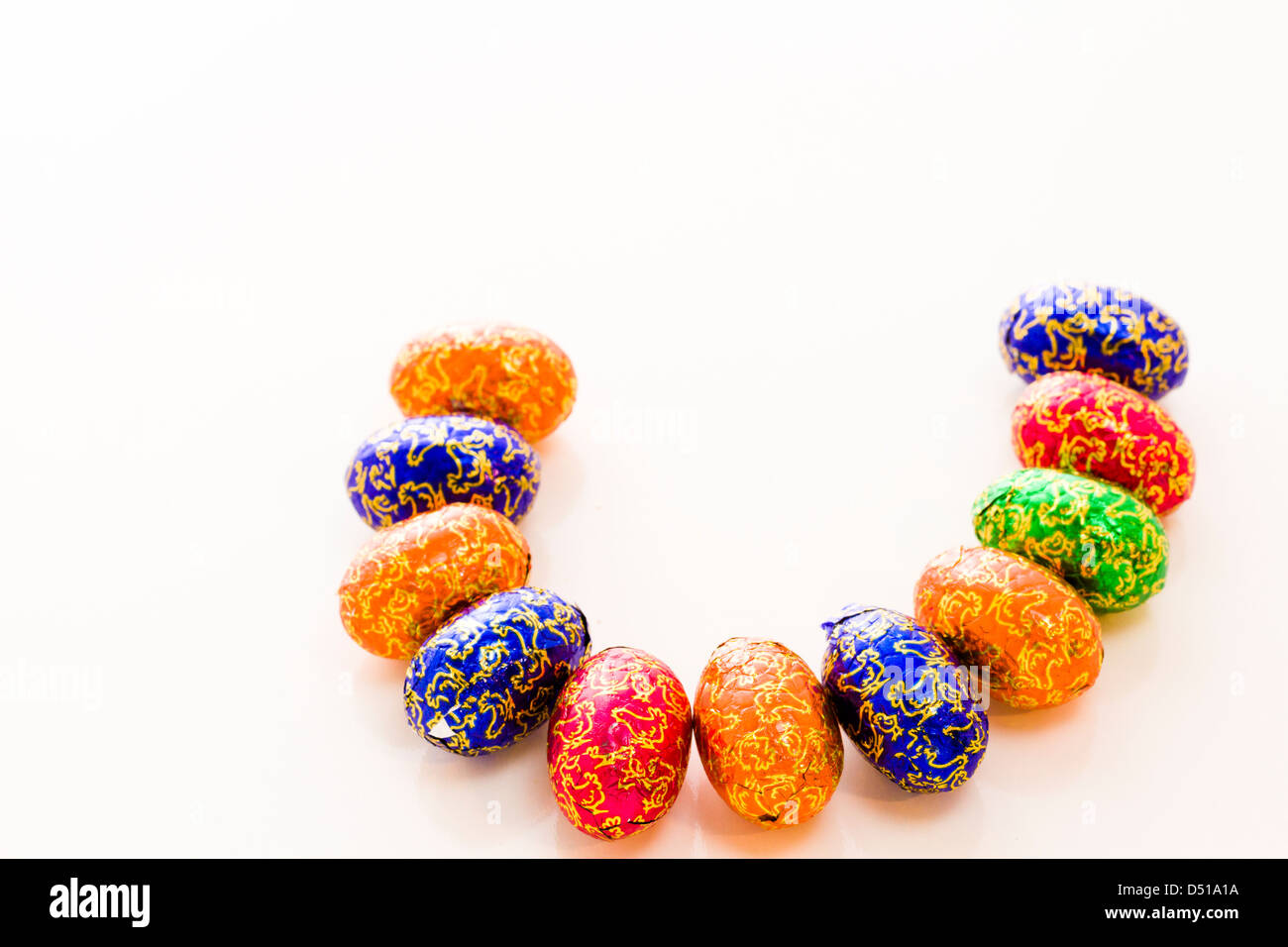 Chocolate eggs wrapped in bright foils on a white background Stock ...