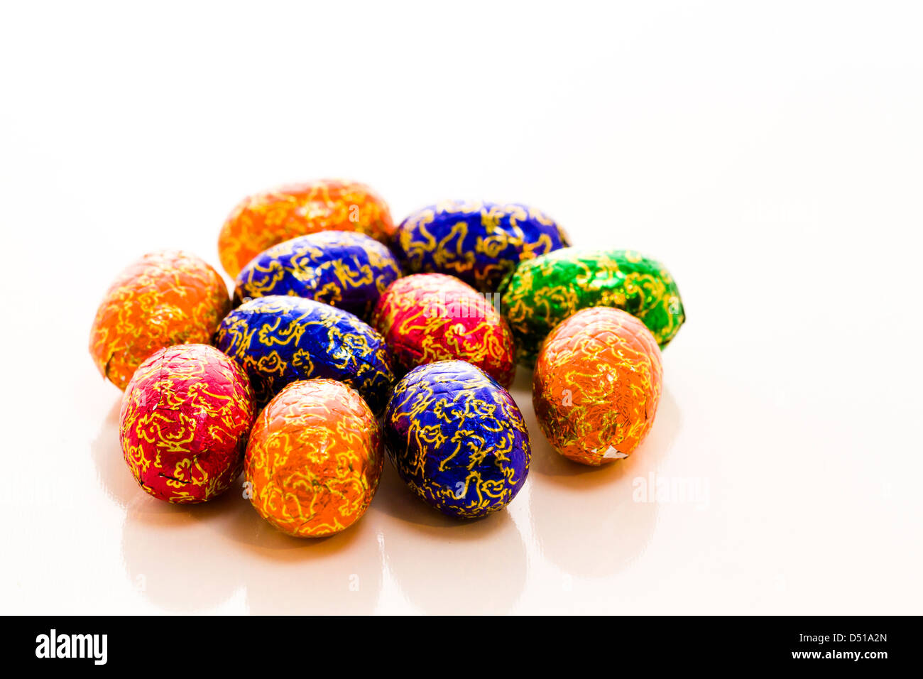 Chocolate eggs wrapped in bright foils on a white background Stock ...