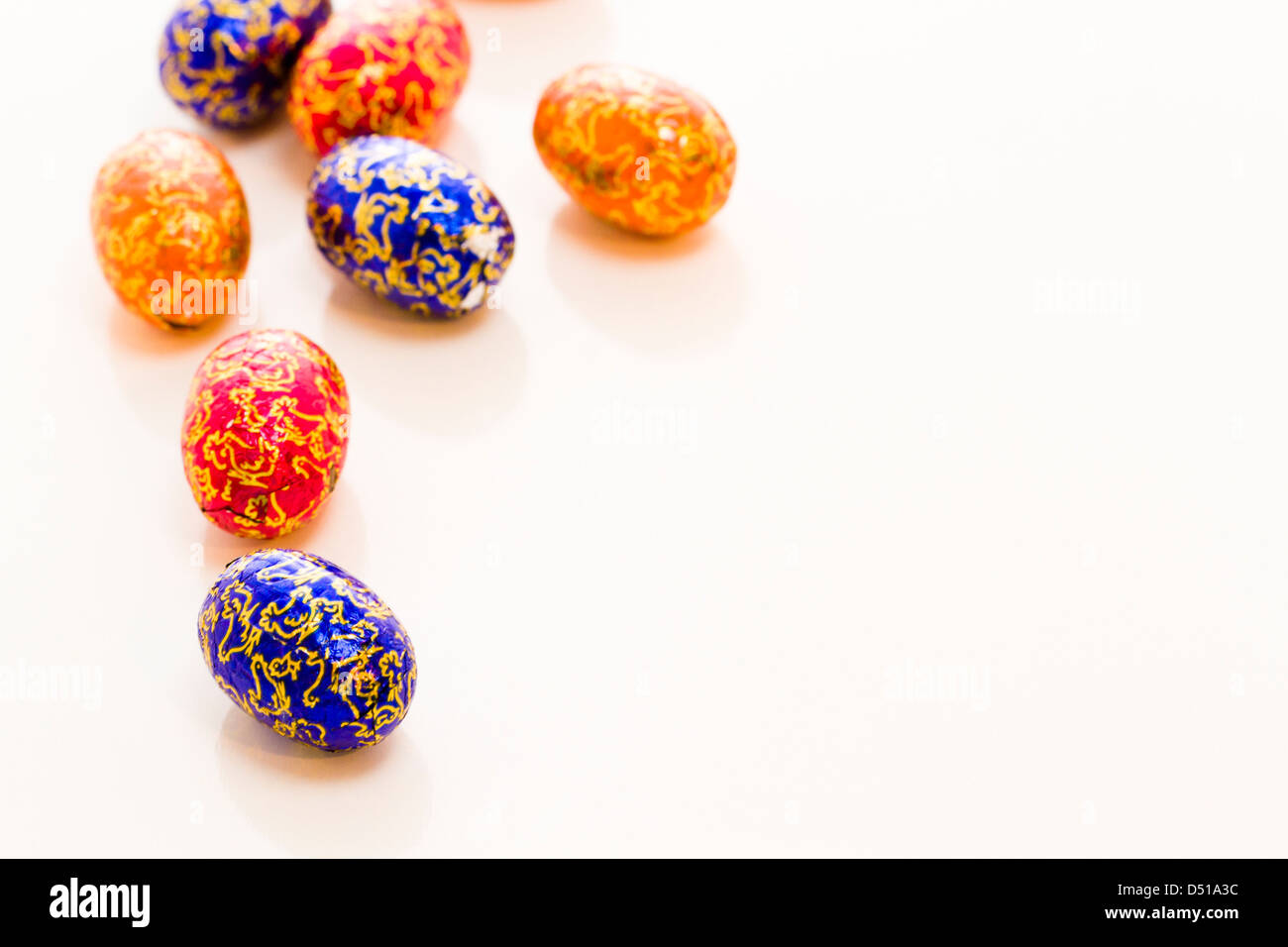 Chocolate eggs wrapped in bright foils on a white background Stock ...