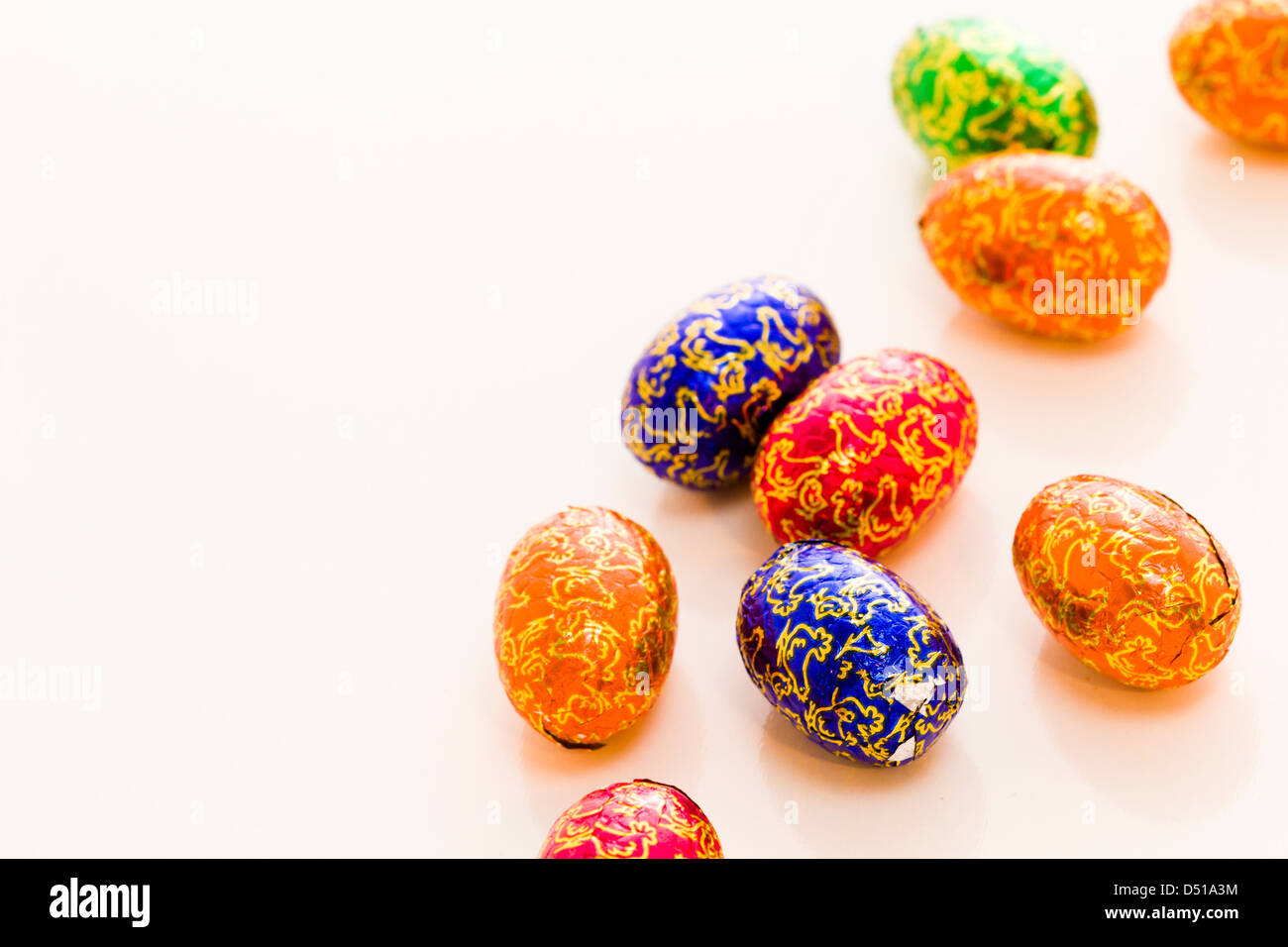 Chocolate eggs wrapped in bright foils on a white background Stock ...
