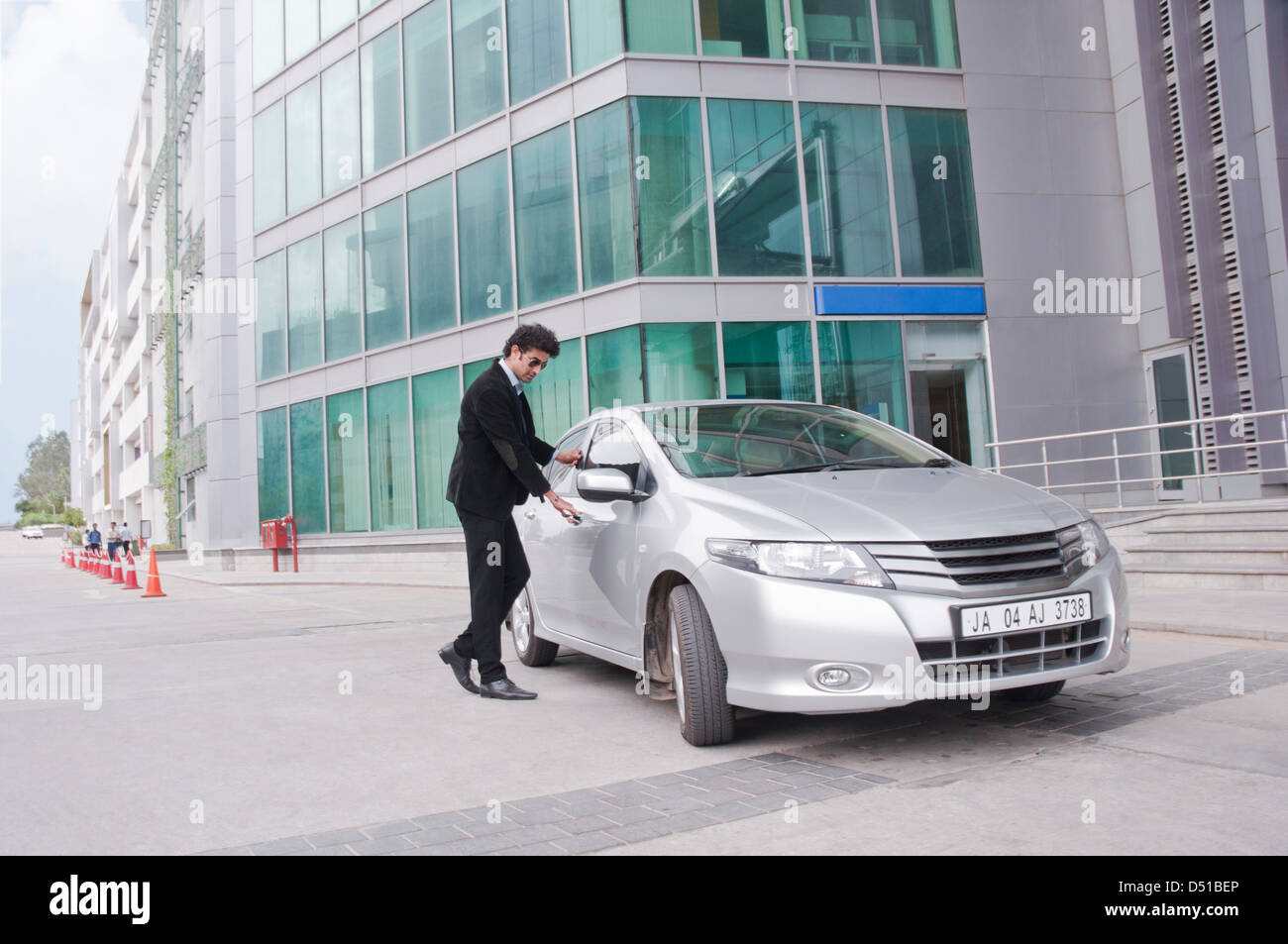 Businessman getting into a car in front of an office building Stock ...