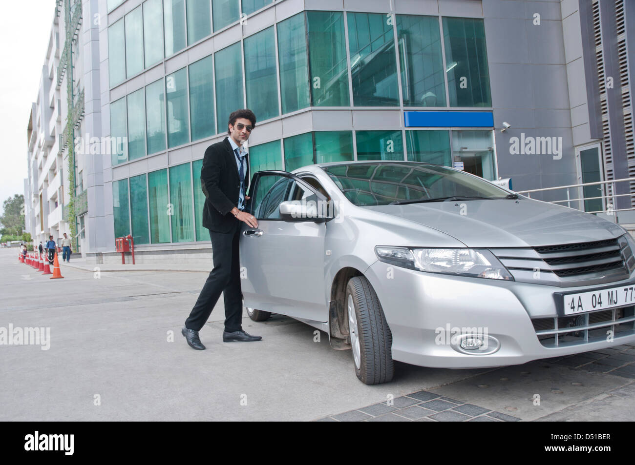 Businessman getting into a car in front of an office building Stock ...