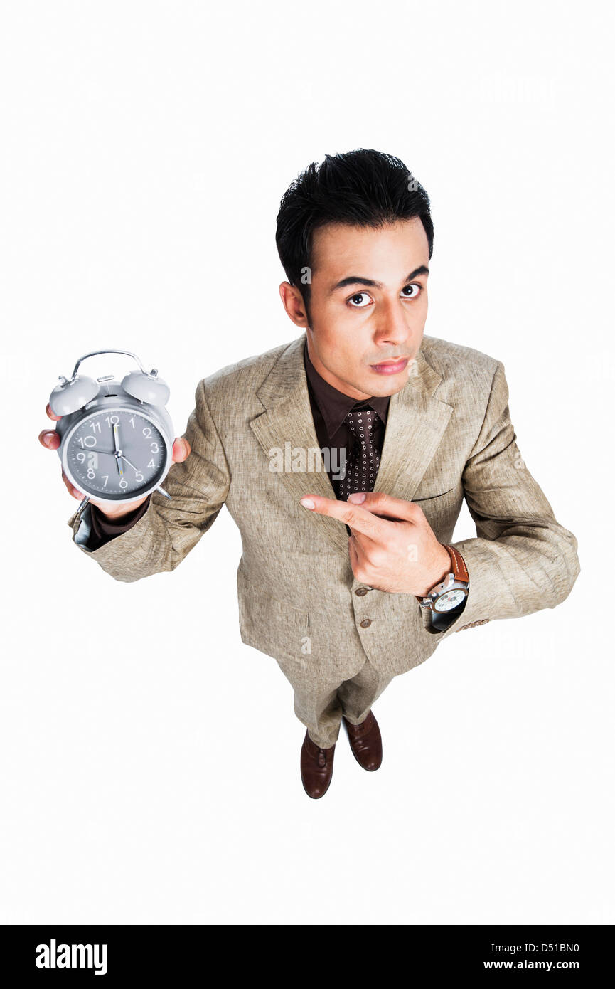 Angry businessman pointing towards an alarm clock Stock Photo - Alamy Angry businessman pointing towards an alarm clock Stock Photo - Alamy