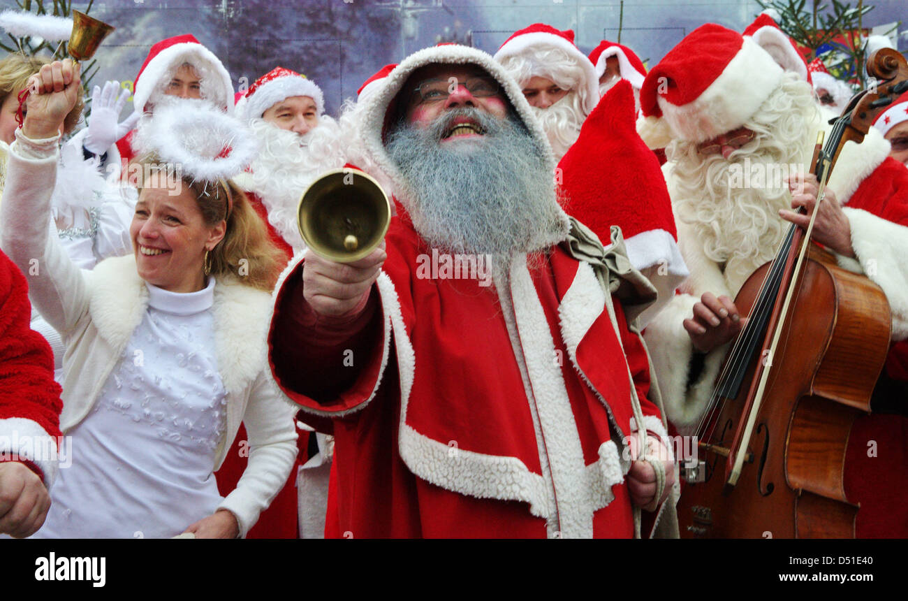 Men in Santa Claus costumes and women in angel costumes meet on the ...
