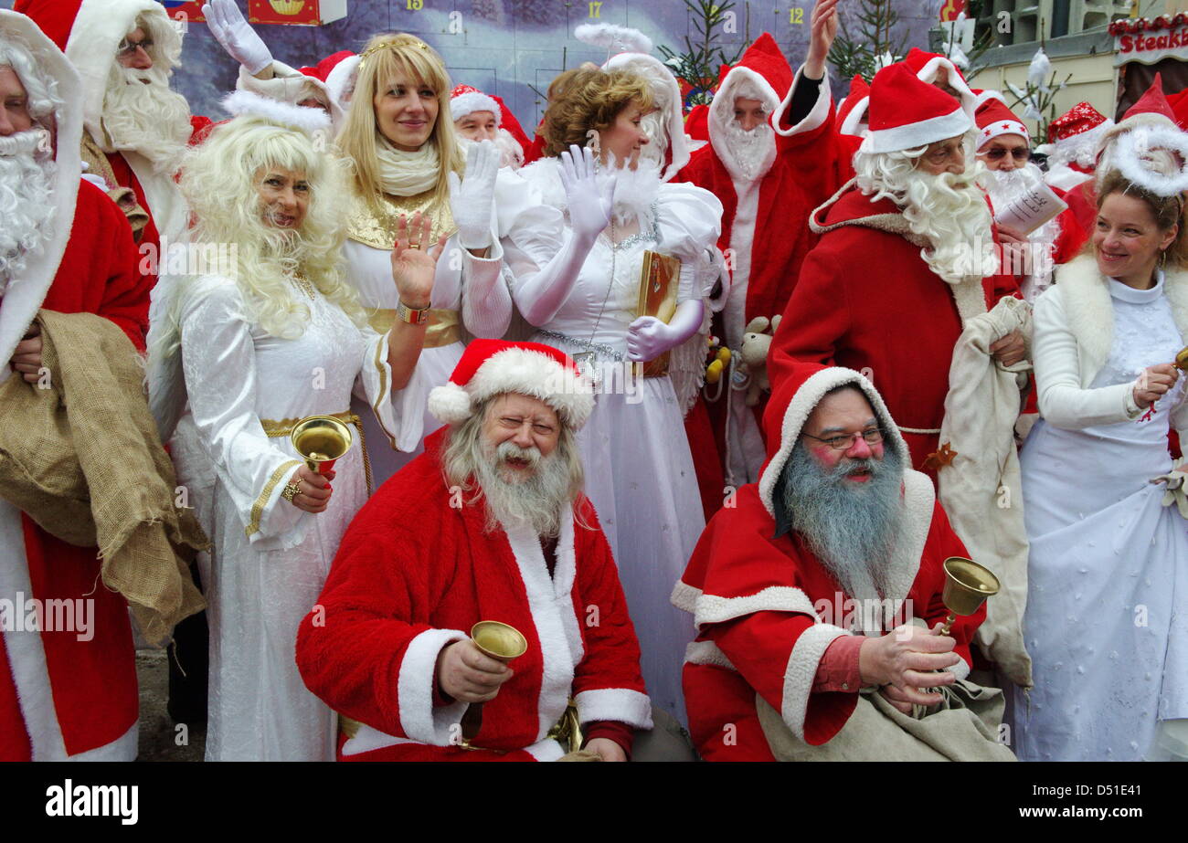 Men in Santa Claus costumes and women in angel costumes meet on the ...