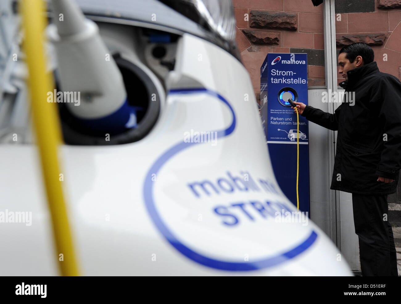 An electronic car stands in front of a new type of ticket vending ...